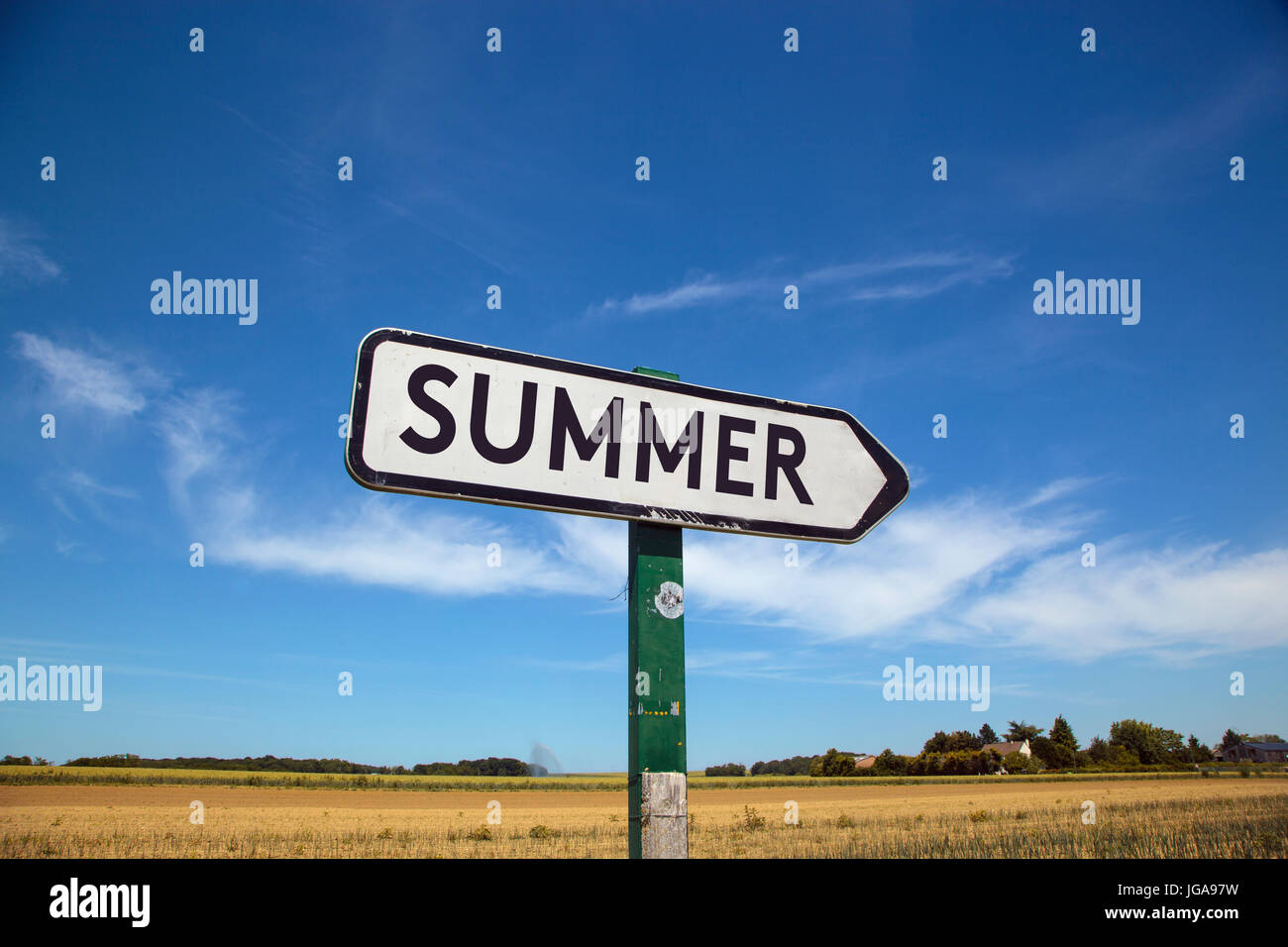 In the countryside a road sign with the inscription summer, with a blue ...