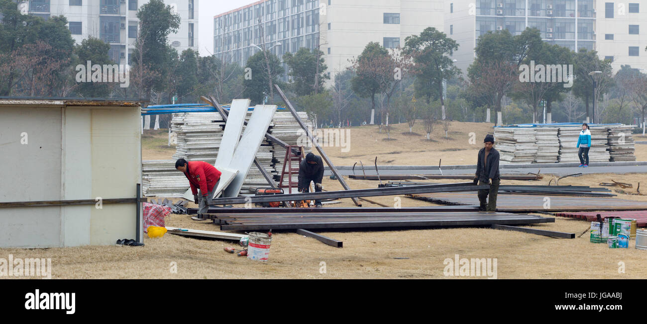 Iron angle bars being cut and erected to support composite fence panels ...