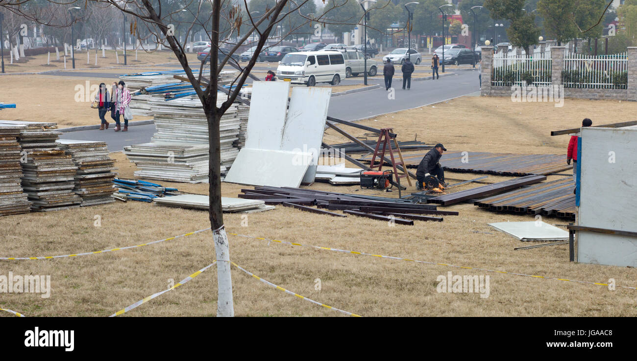 Iron angle bars being cut and erected to support composite fence panels ...