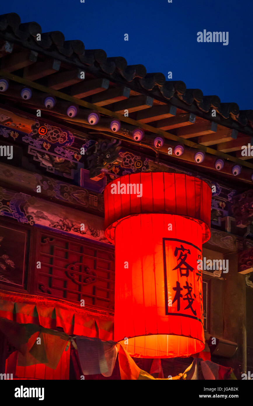 Illuminated traditional Chines lantern hanging in front of a house ...