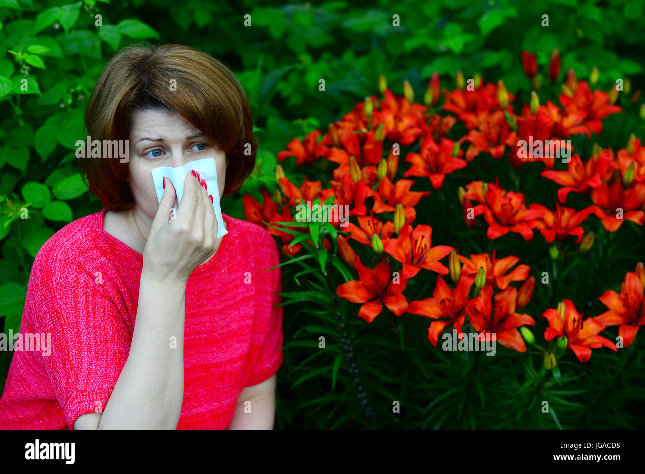 woman with an allergic rhinitis near lilies in nature Stock Photo - Alamy