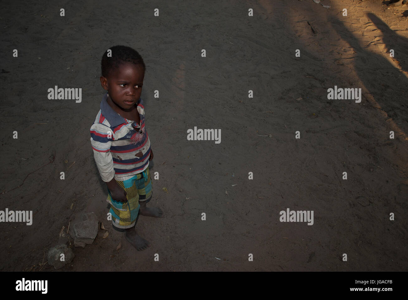 small african boy in the shadows of grown ups Stock Photo - Alamy