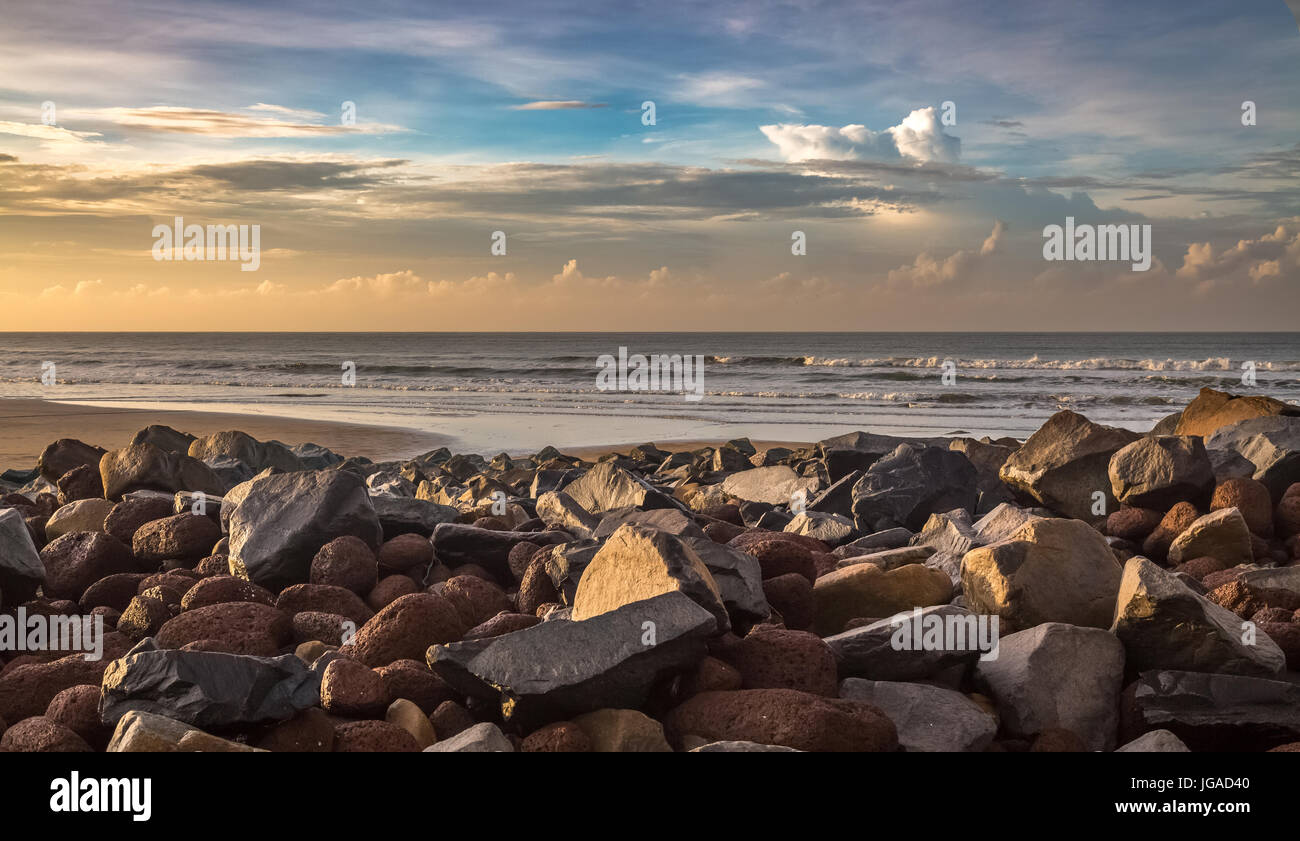 Sunrise at Indian beach with seascape rocks and moody sky Stock Photo ...
