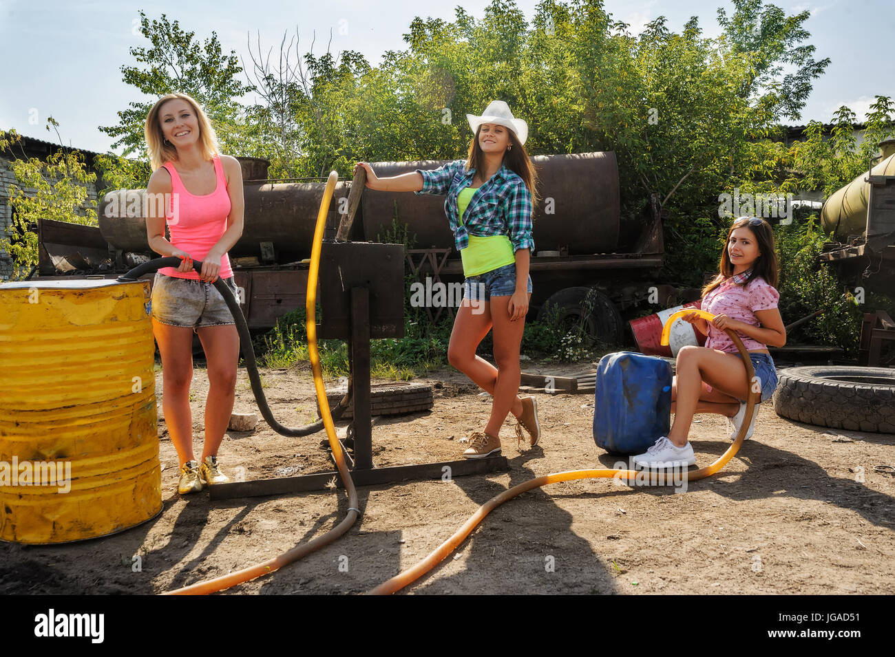 Young women on old gasoline station fill canister Stock Photo - Alamy