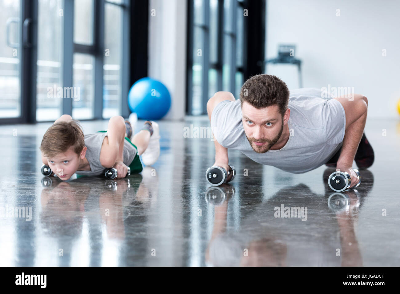 Man and boy doing push ups at fitness center Stock Photo - Alamy