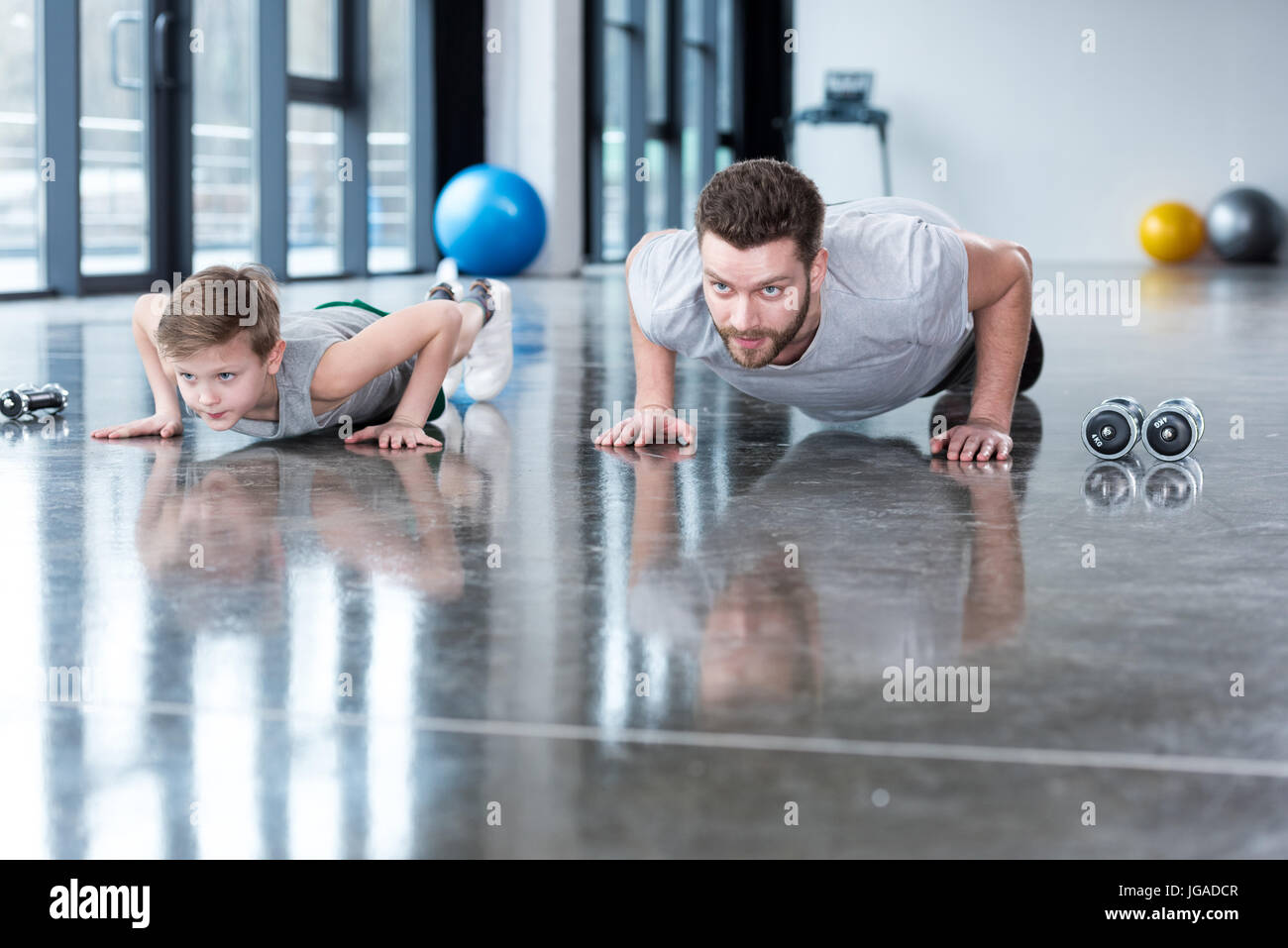 Man and boy doing push ups at fitness center Stock Photo - Alamy