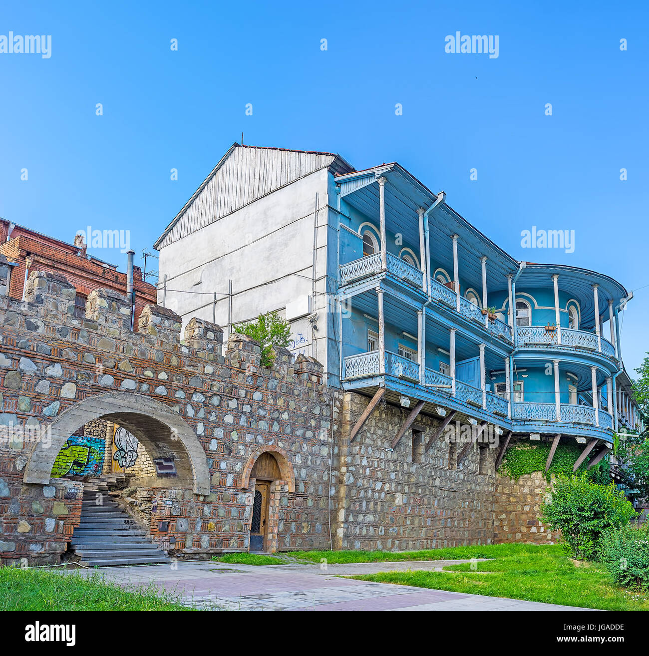 The fortress wall in old Tbilisi and the old mansion, decorated with ...