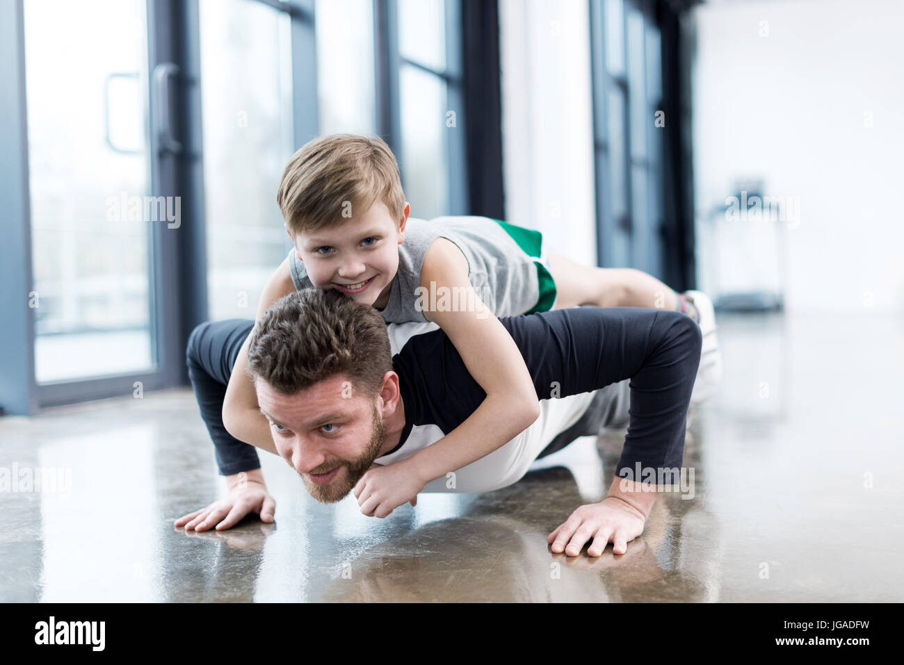Man doing push ups with boy on his back Stock Photo - Alamy