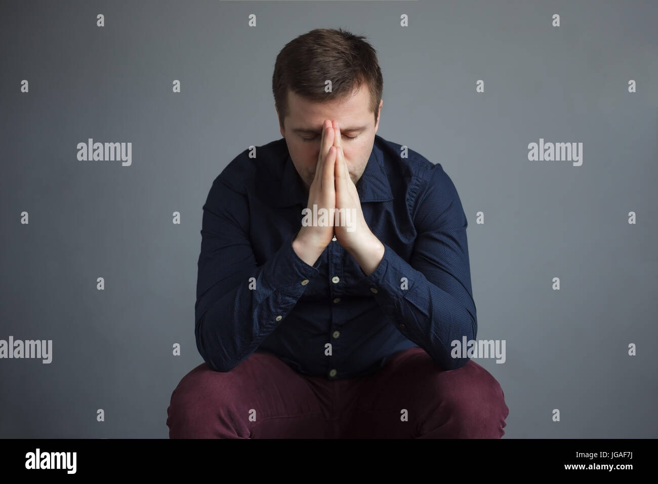 Handsome depressed man on grey background Stock Photo - Alamy