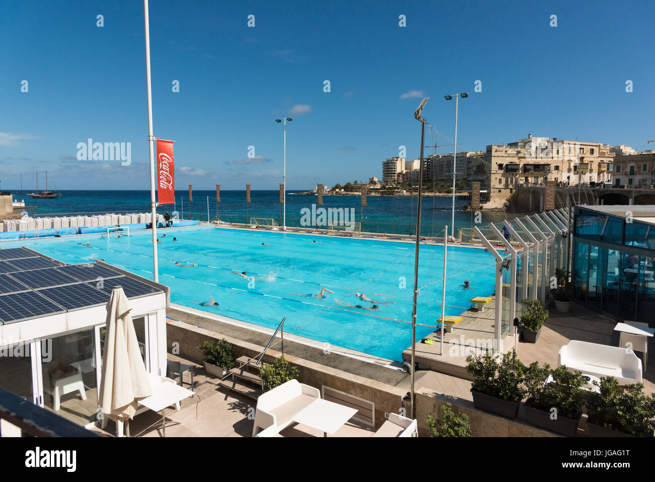 An outdoor swimming pool with people swimming on the coast at Balluta ...