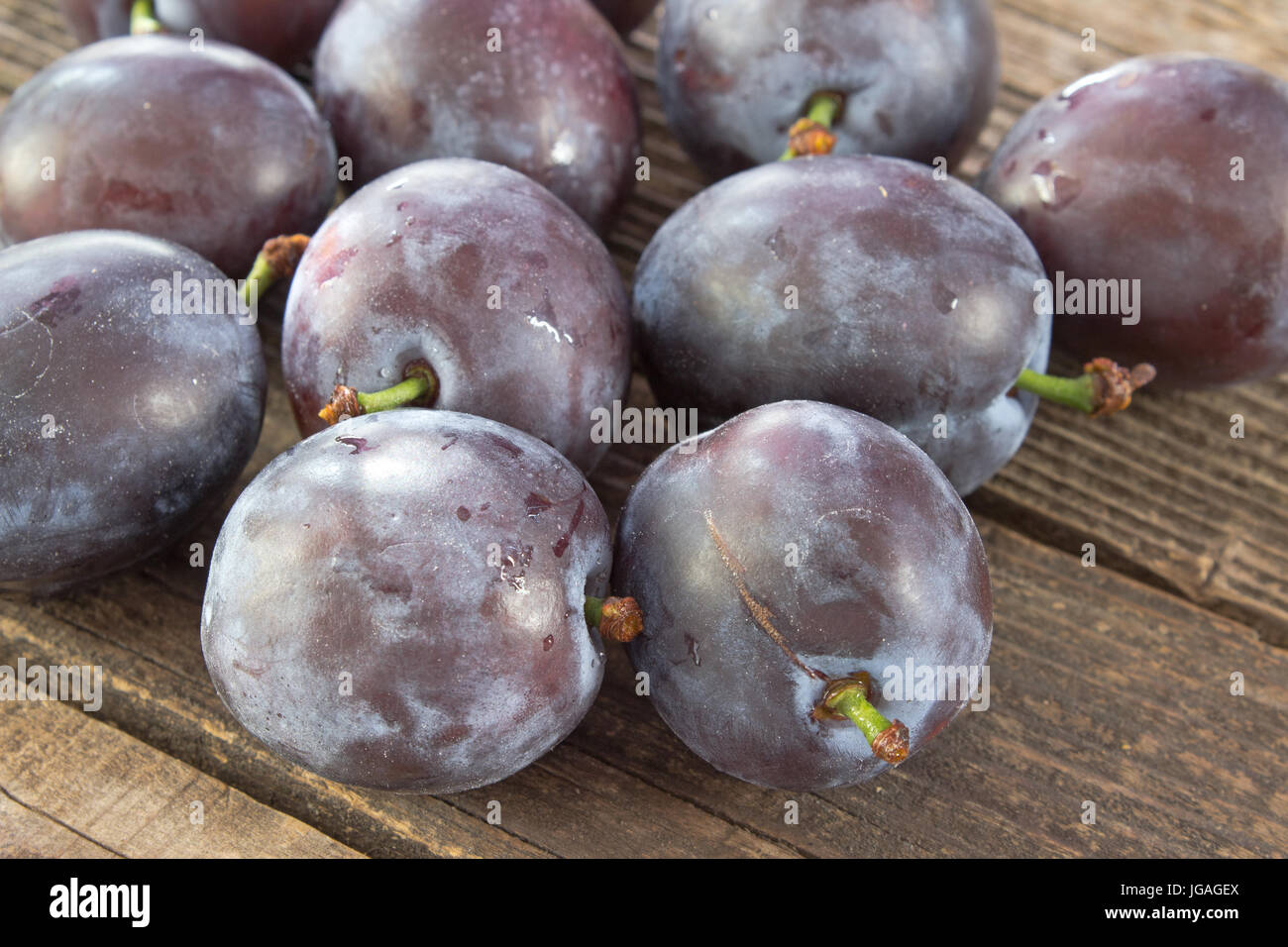 Ripe plums on wooden background Stock Photo - Alamy