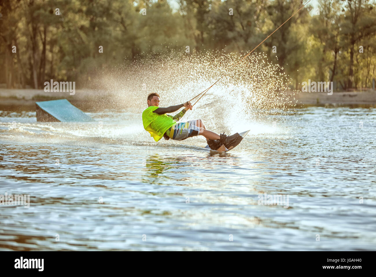 Guy rushes along the lake on the board, extreme sport wakeboarding ...