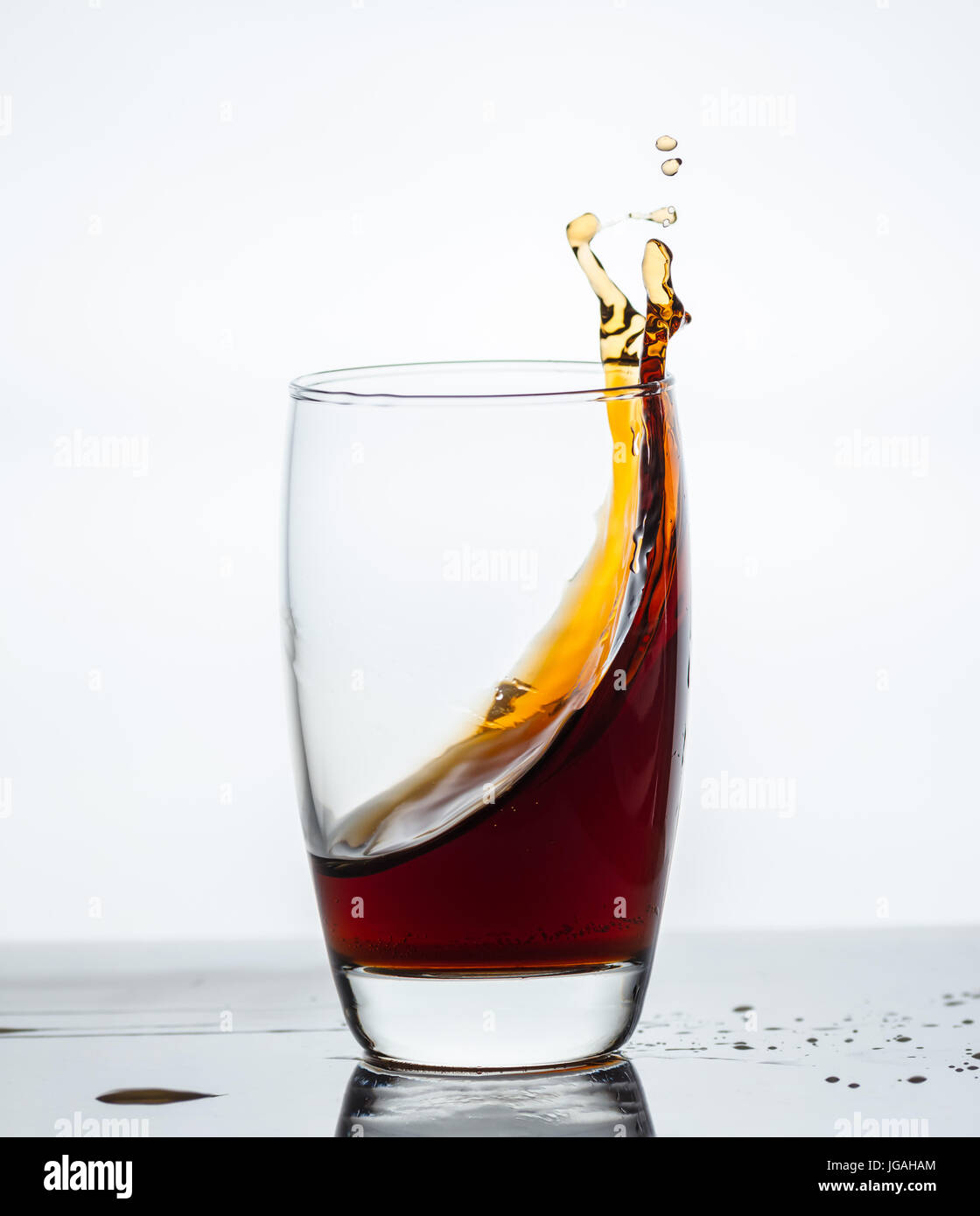 splash of drink from a glass with reflection Stock Photo - Alamy
