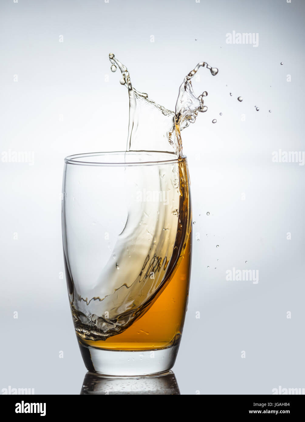 splash of drink from a glass with reflection Stock Photo - Alamy