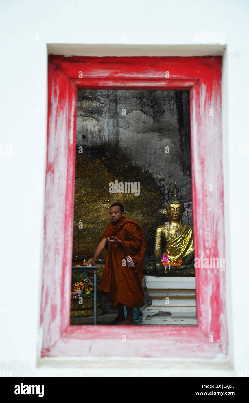 Monk respect praying and gild cover with gold leaf at Lord Buddha image ...