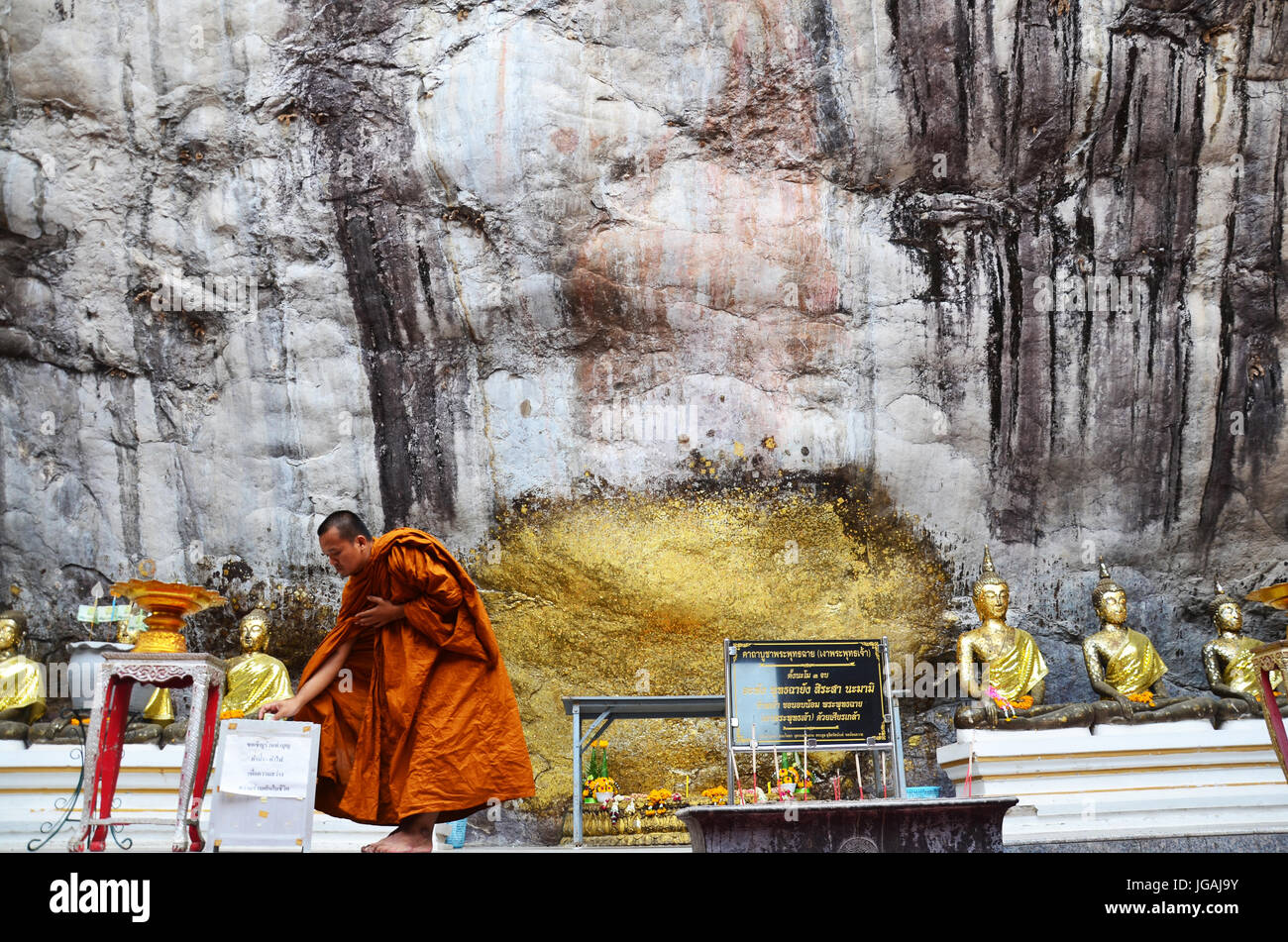 Monk respect praying and gild cover with gold leaf at Lord Buddha image ...