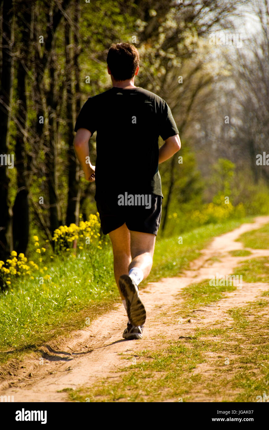 young man running along a path in the park Stock Photo - Alamy