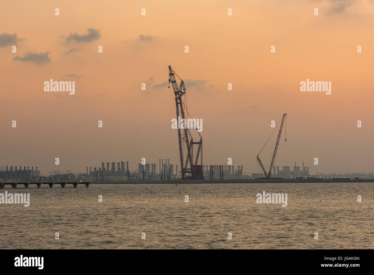 Sunset at the Dubai seaport, UAE. Silhouette of cranes on a bright sky ...