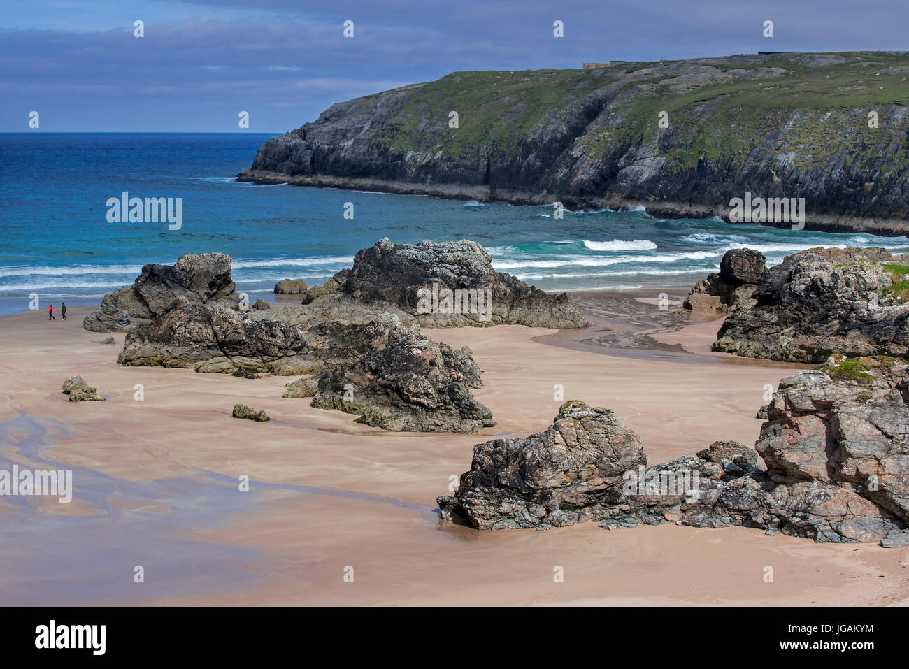 Tourists walking on sandy beach with rocks near Durness, Sutherland ...