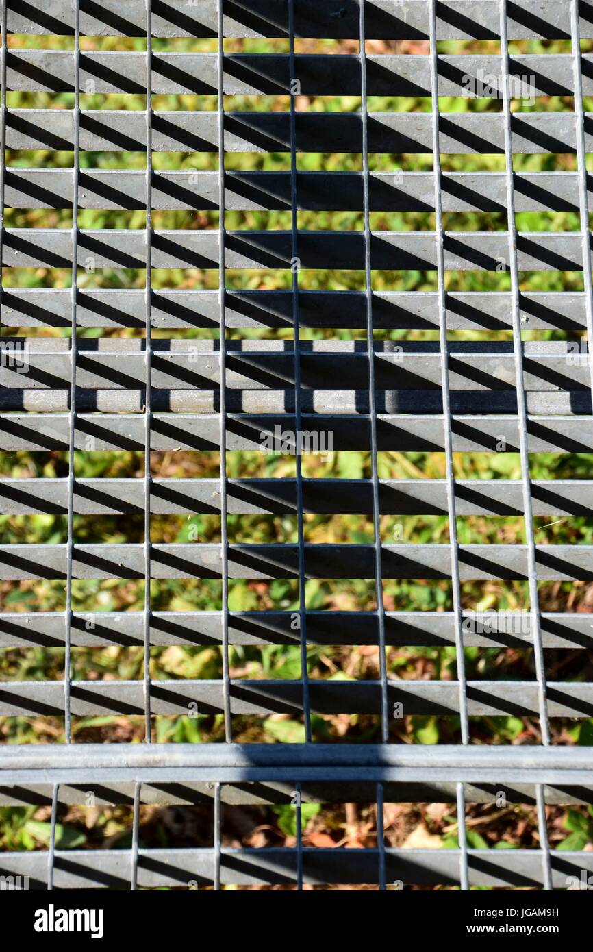 metal grid with holes over a meadow in shadow and sunlight optic Stock ...