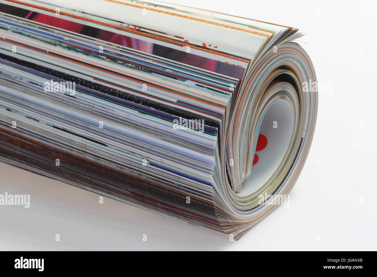 Rolled up magazine on bright background Stock Photo - Alamy
