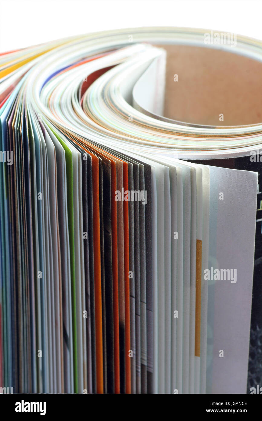Rolled up magazine on bright background Stock Photo - Alamy