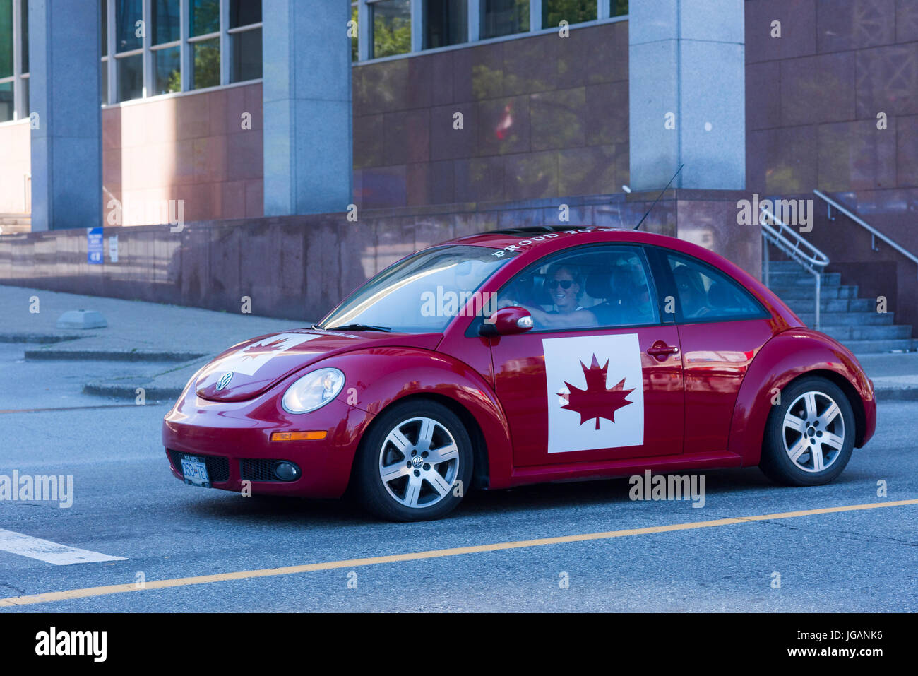 Woman driving Volkswagen Beetle car celebrating being Canadian Stock ...