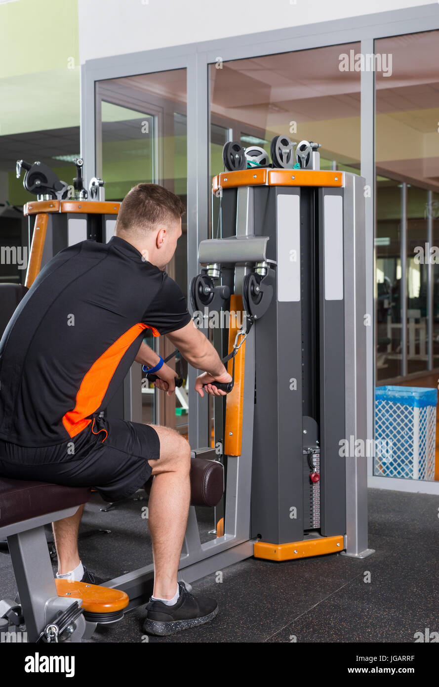 Fit man training on row machine in gym room in fitness center Stock ...