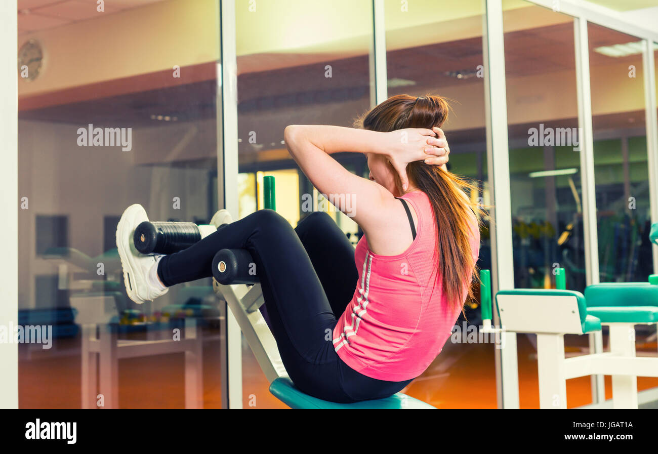 Sporty woman doing sit-up using training apparatus in a gym Stock Photo ...