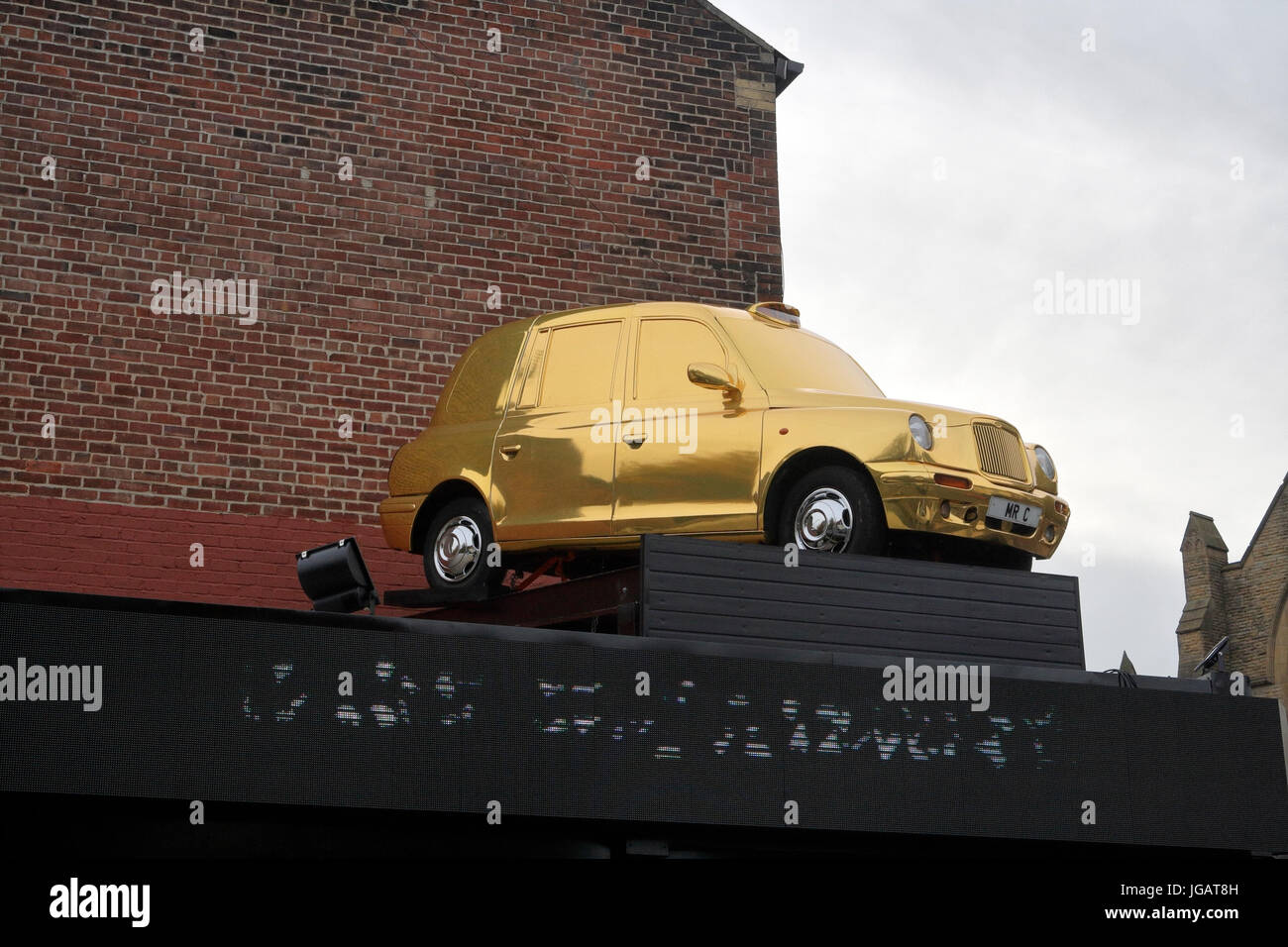 Gold painted taxi cab advertising on roof of building Abbeydale road ...