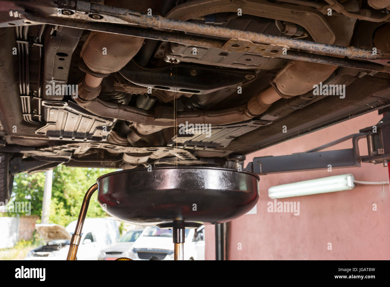 Oil jet flows out into equipment for changing motor oil in automobile ...