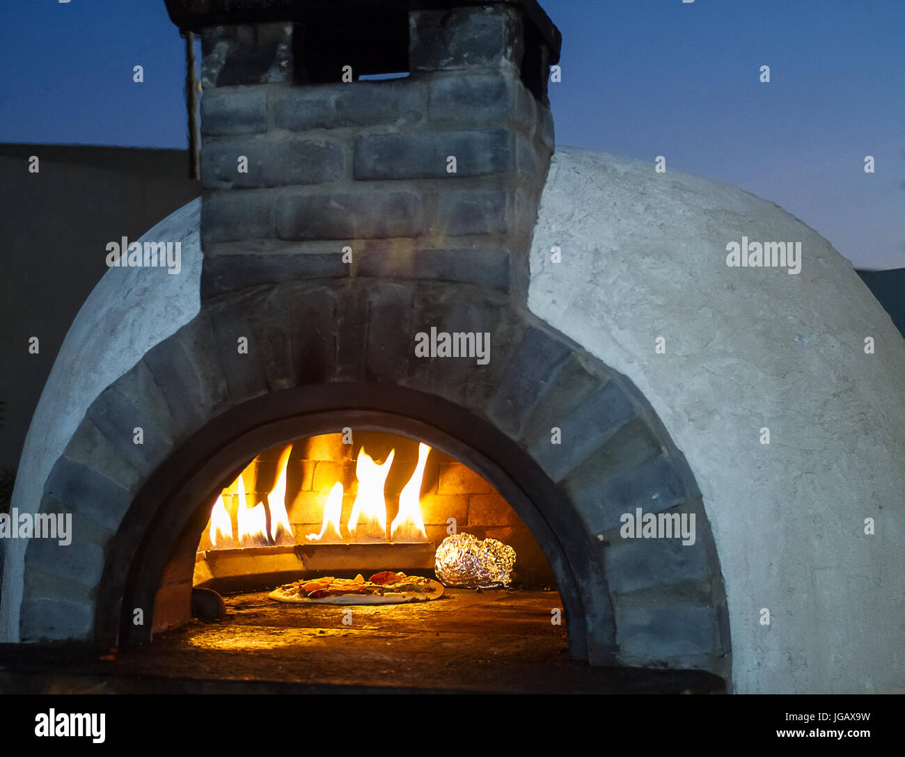 Outdoor stove for baking bread with pizza inside Stock Photo - Alamy
