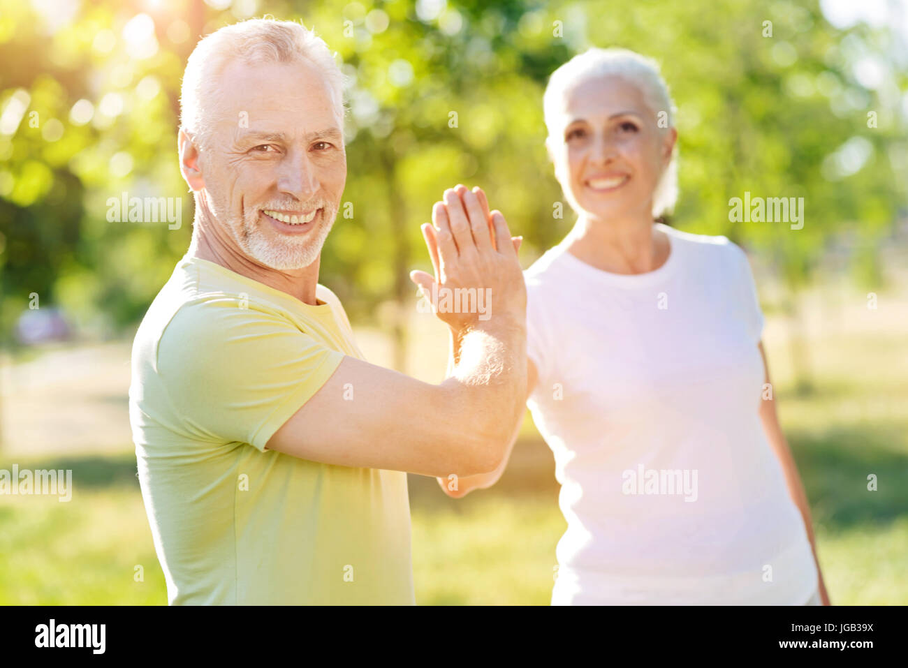Positive senior couple giving high five outdoors Stock Photo - Alamy