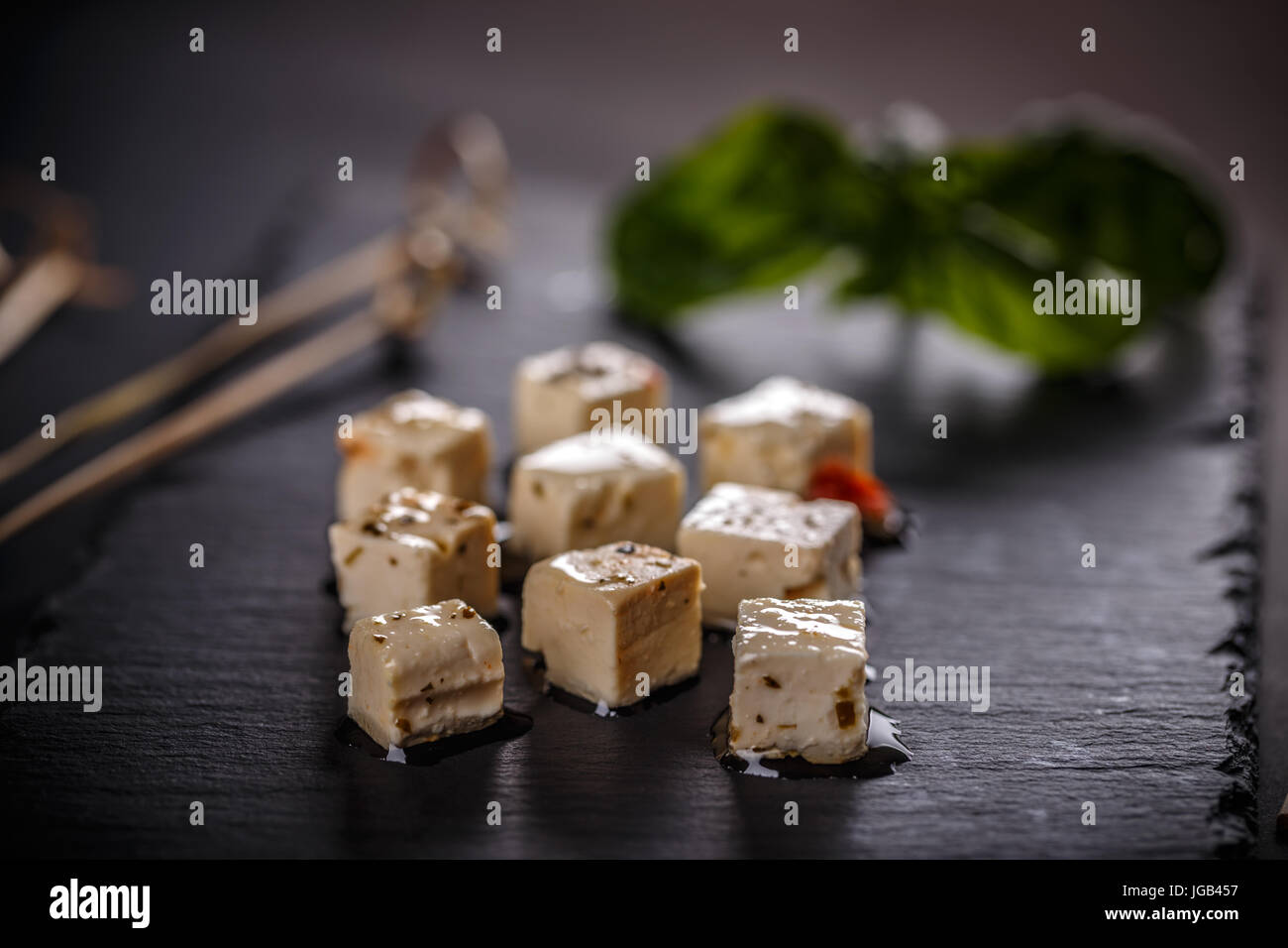 Cubes of cheese, seasoned with herbs, close up Stock Photo - Alamy