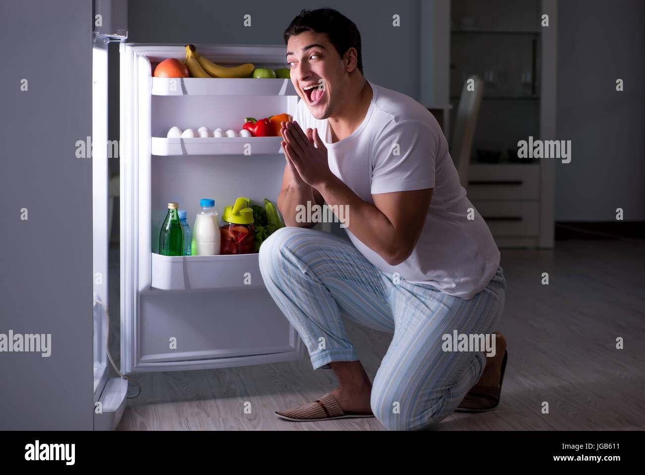 Man opening refrigerator at night hi-res stock photography and images ...