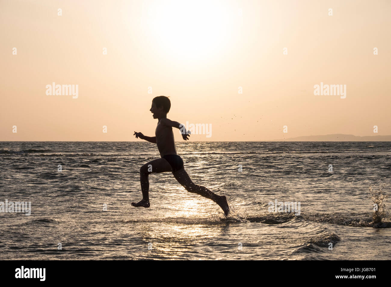 Boy running with joy on the water Stock Photo - Alamy