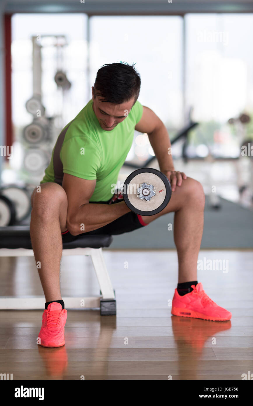 young handsome man working out with dumbbells in a fitness gym Stock ...