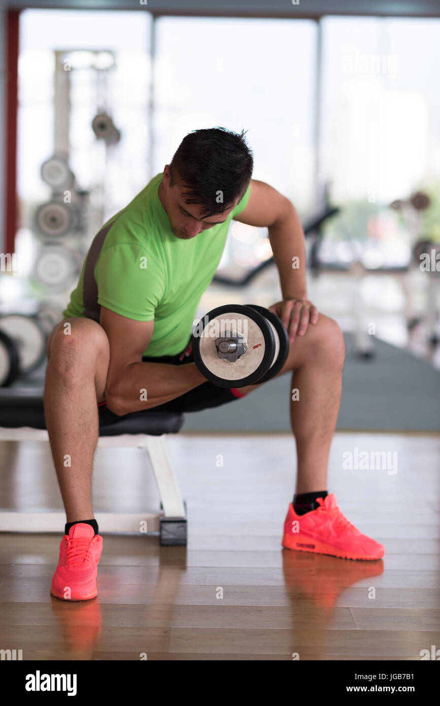 young handsome man working out with dumbbells in a fitness gym Stock ...