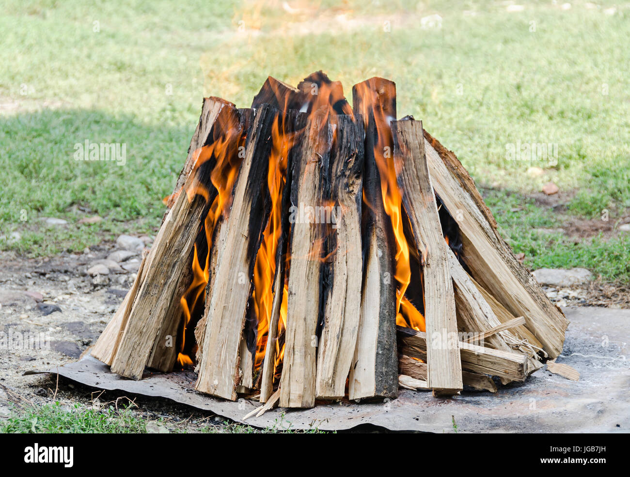 Wood logs in fire, outdoor fire for barbecue, colored flames, close up ...