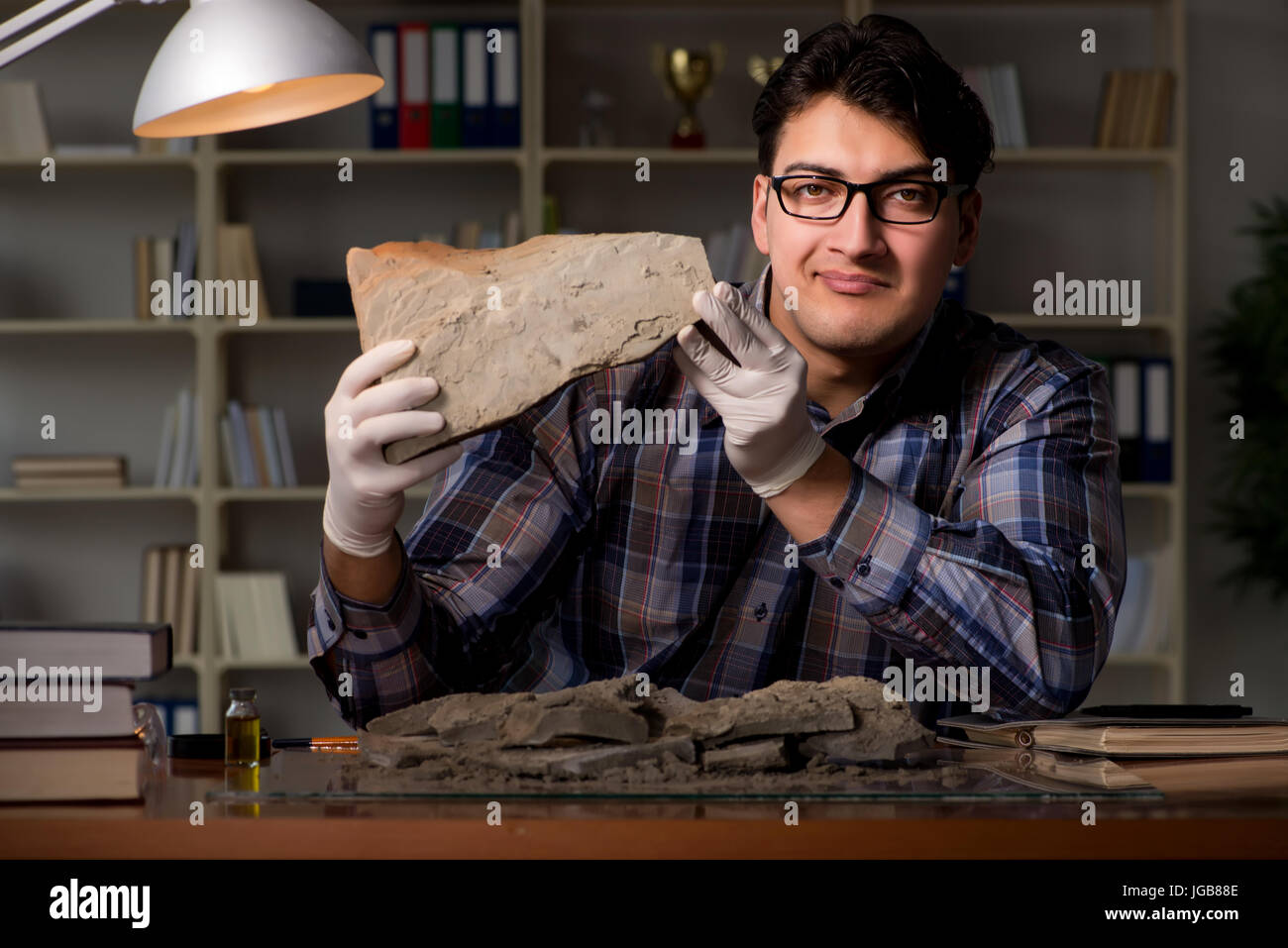 Archeologist working late night in office Stock Photo - Alamy