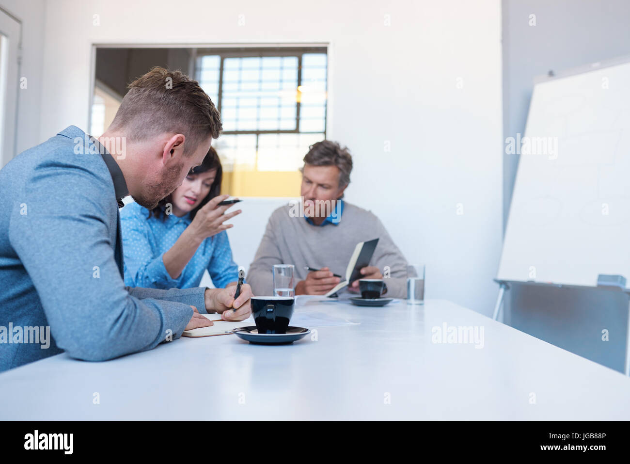 Work colleagues talking business together in an office Stock Photo - Alamy