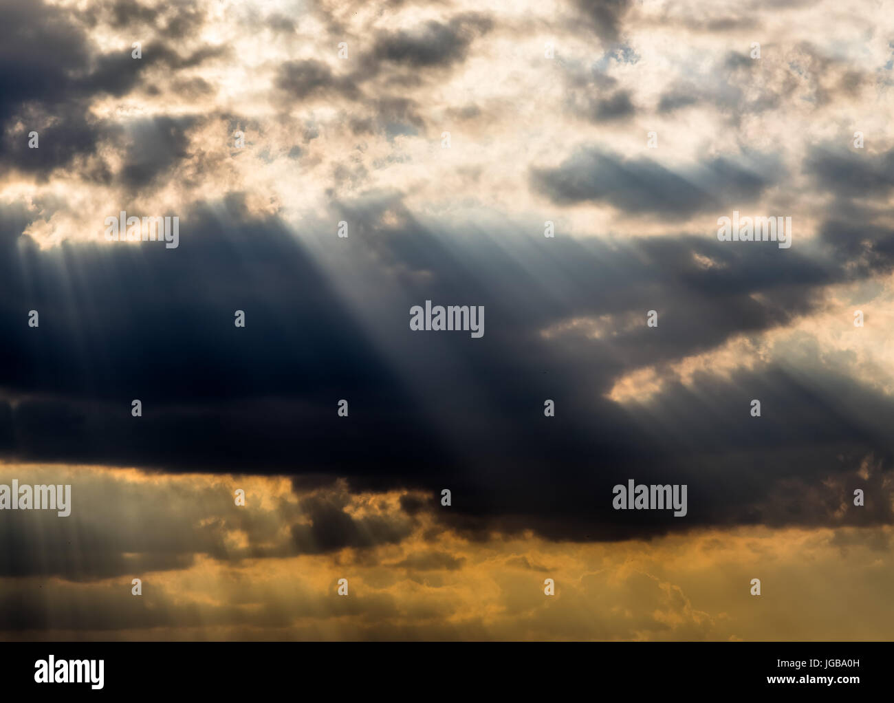 Beautiful sun shafts light coming through large and dark clouds, with a ...