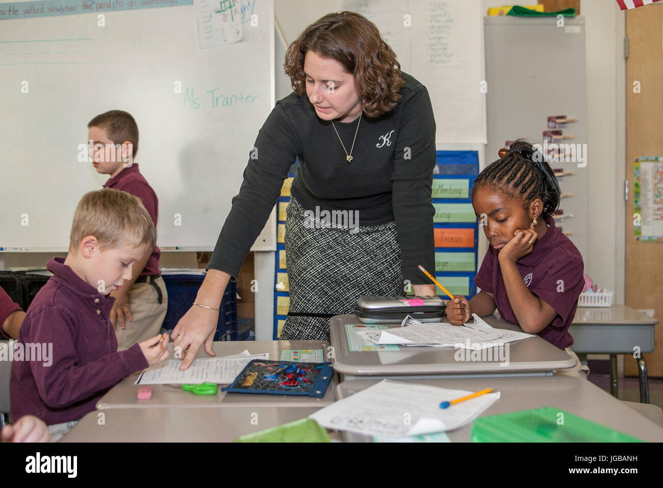Teacher helping her elementary school student in class Stock Photo - Alamy