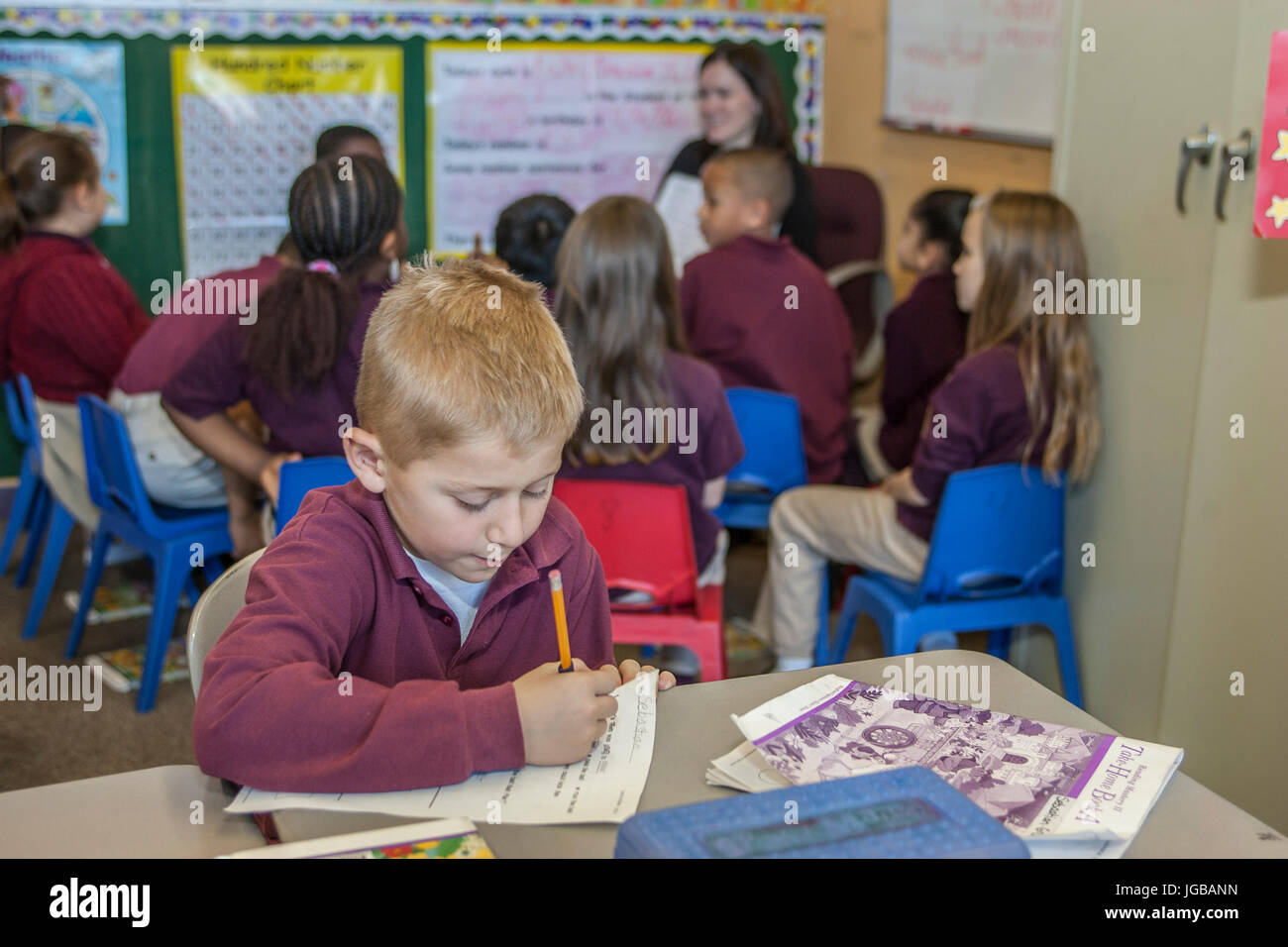 Boy working on an assignment in the elementary school classroom Stock ...