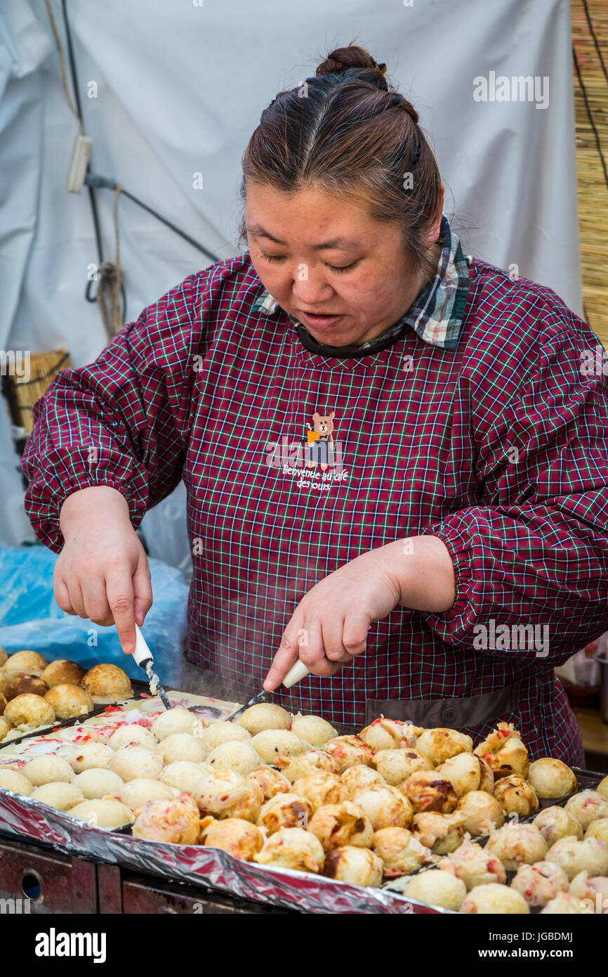 A street food vendor preparing traditional Japanese dishes in Asakusa ...