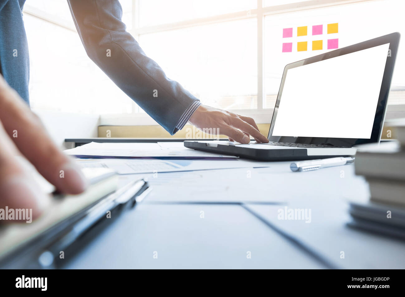 Casual businessman working in office, sitting at desk, typing on ...
