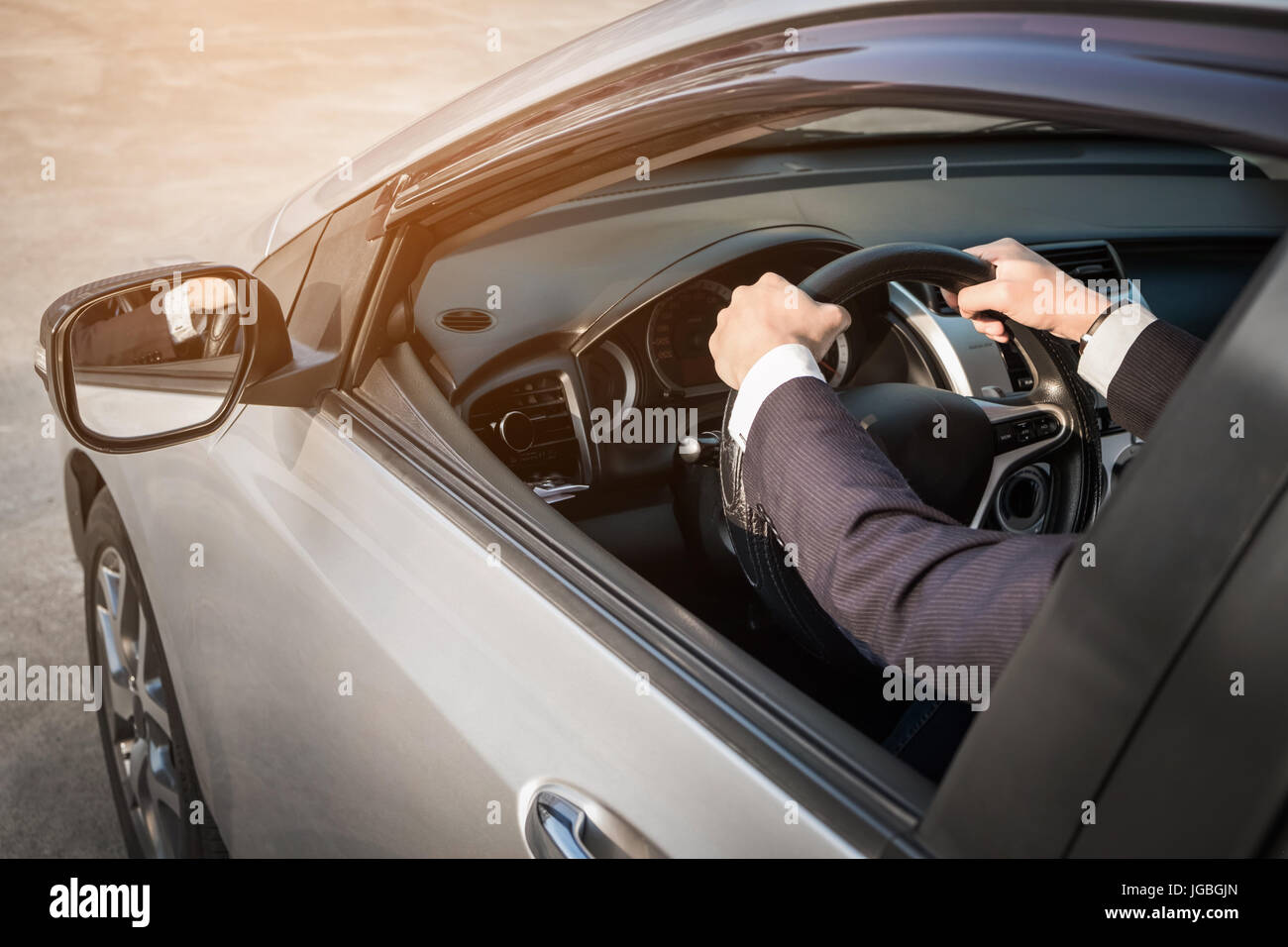 Portrait of a young handsome businessman driving a luxury sports car ...