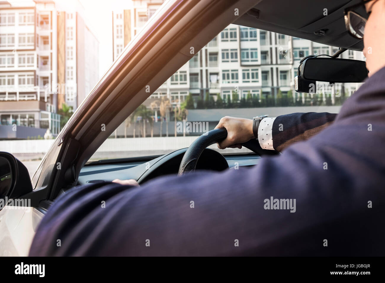 Portrait of a young handsome businessman driving a luxury sports car ...