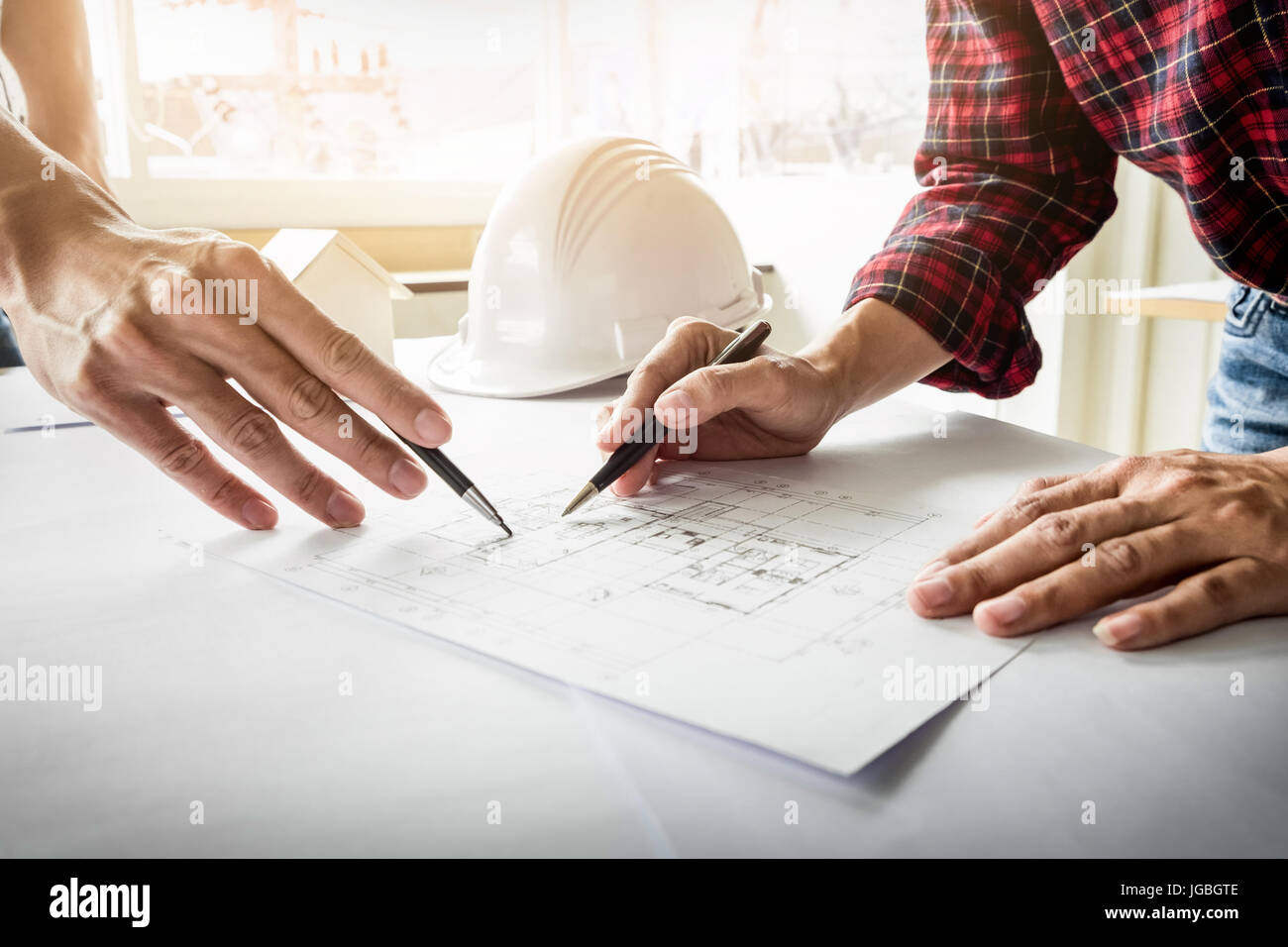 Architects engineer discussing at the table with blueprint - Closeup on ...