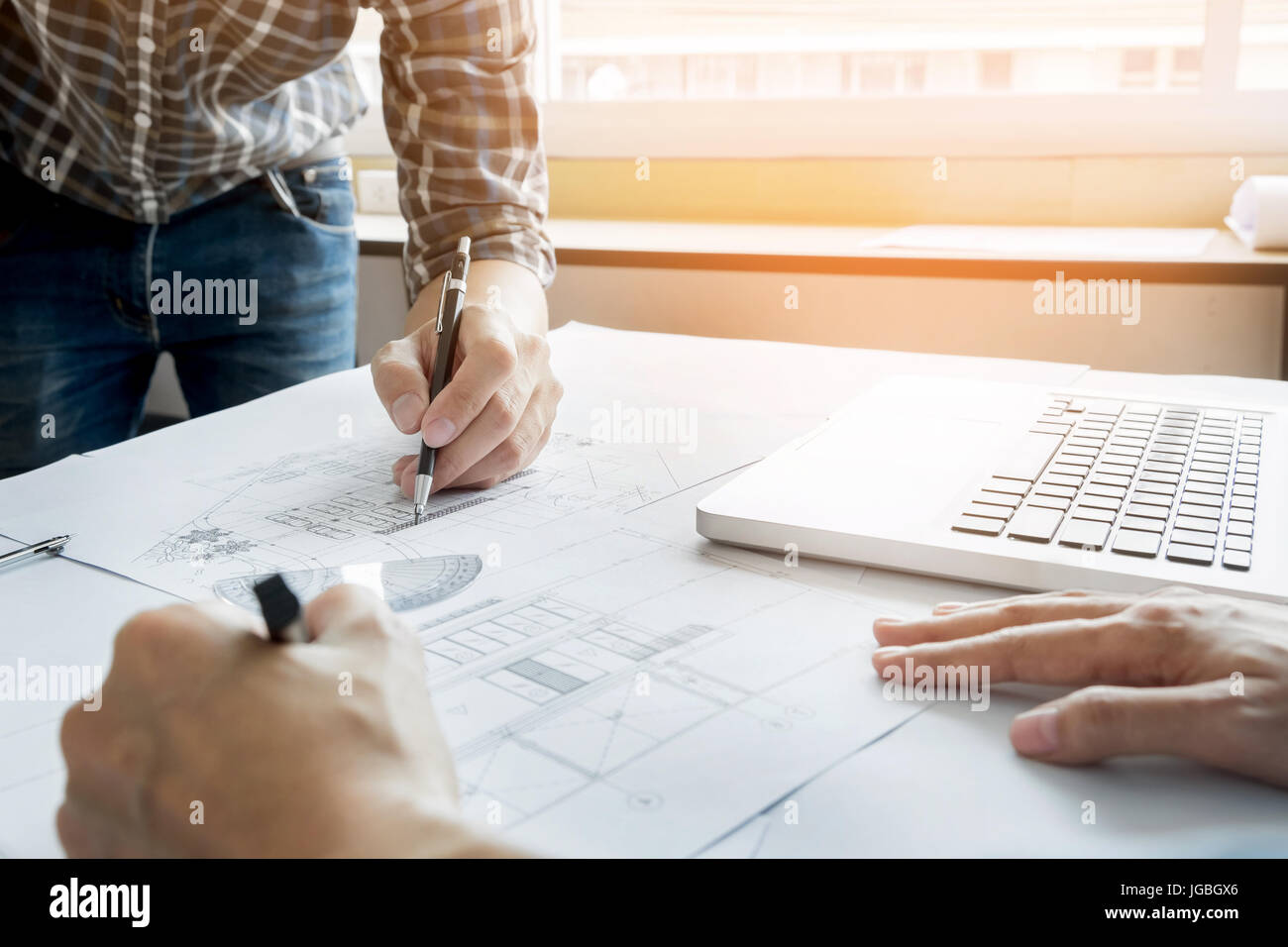 Architects engineer discussing at the table with blueprint - Closeup on ...